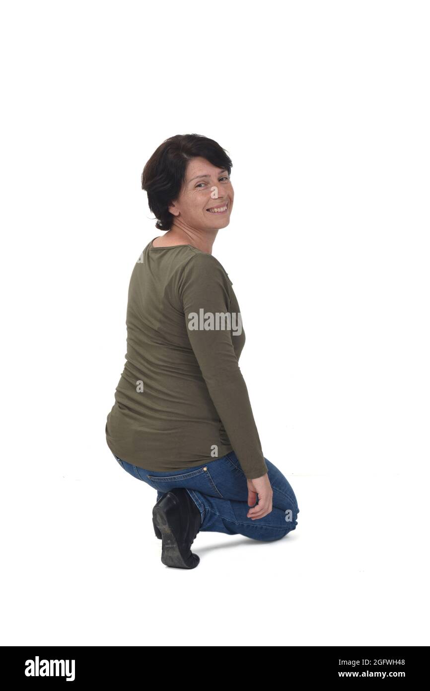 rear view of a woman crouching and looking at camera on white ...