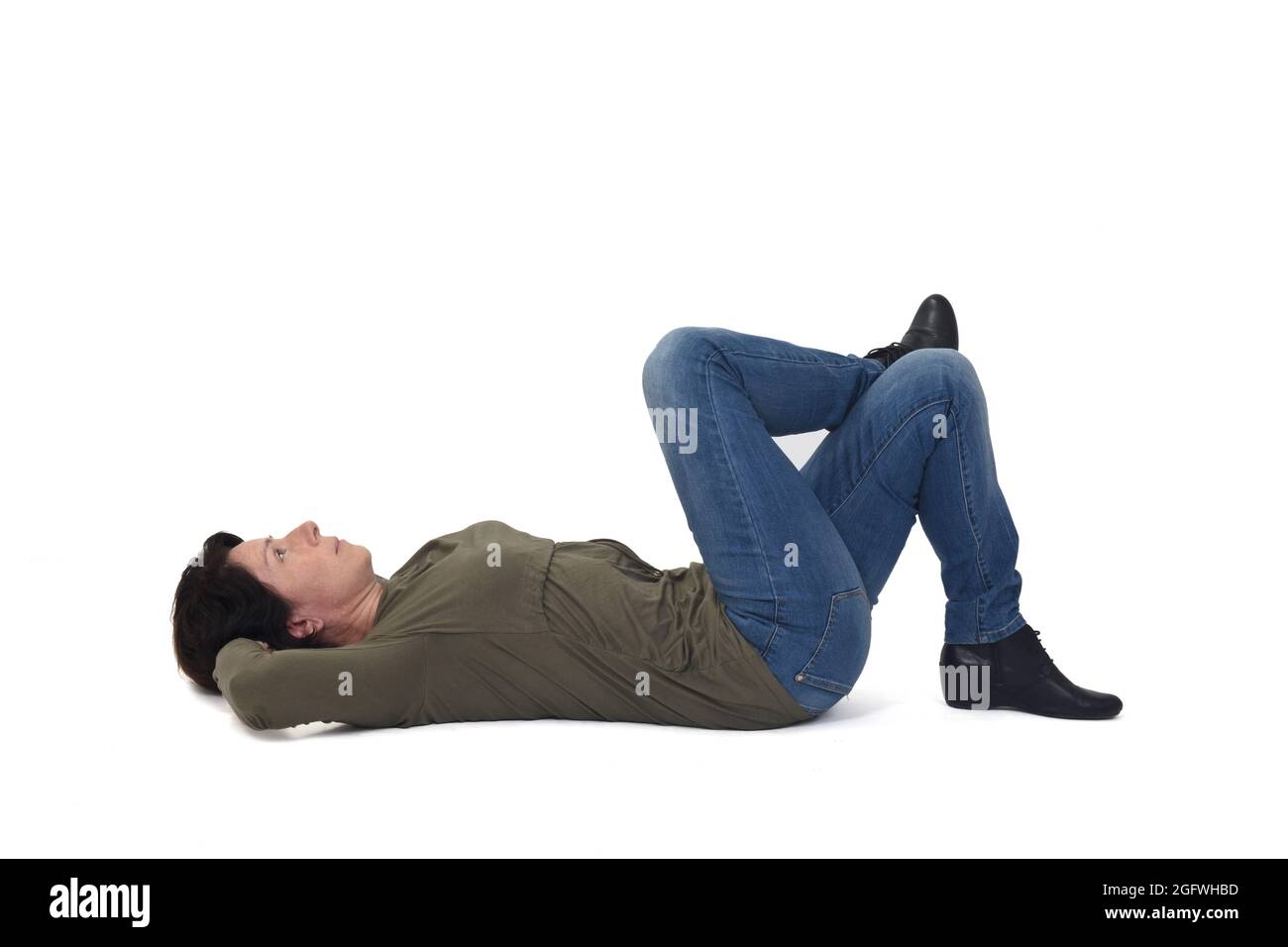 woman lying on the floor looking up and legs crossed on white ...