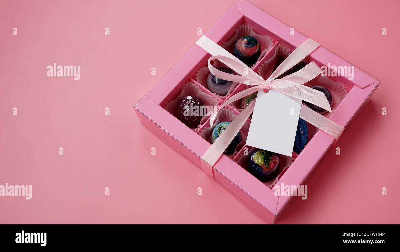 Chocolate candy. Pink gift box with handmade chocolates on a pink ...
