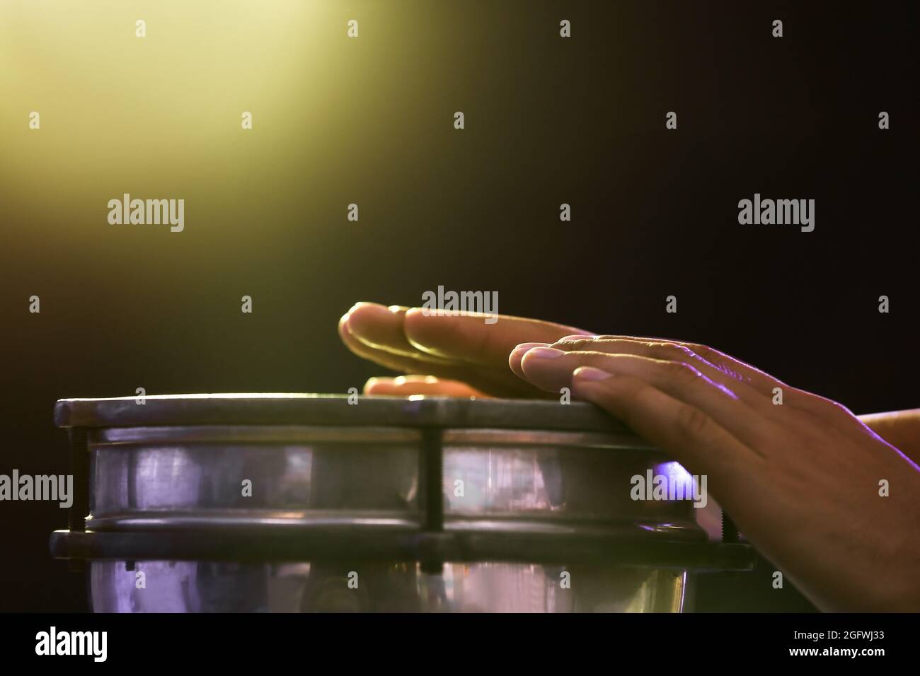 Hands of man playing African drum on dark background Stock Photo - Alamy
