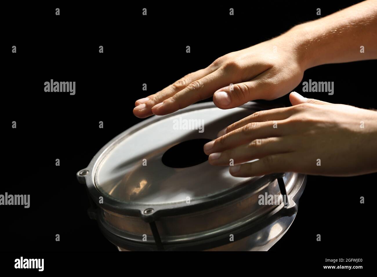 Hands of man playing African drum on dark background Stock Photo - Alamy