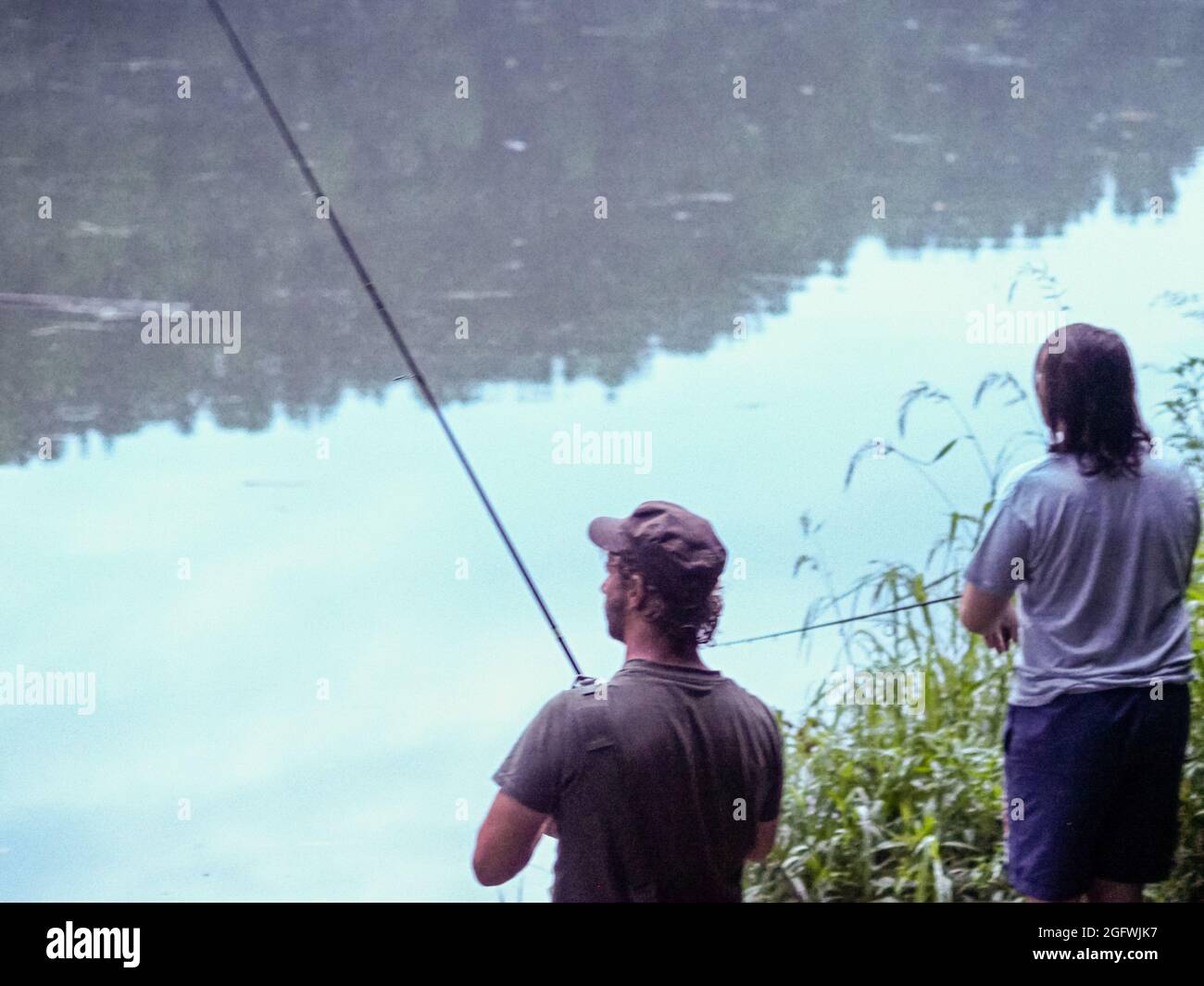 Rear view of men fishing by the river Stock Photo - Alamy