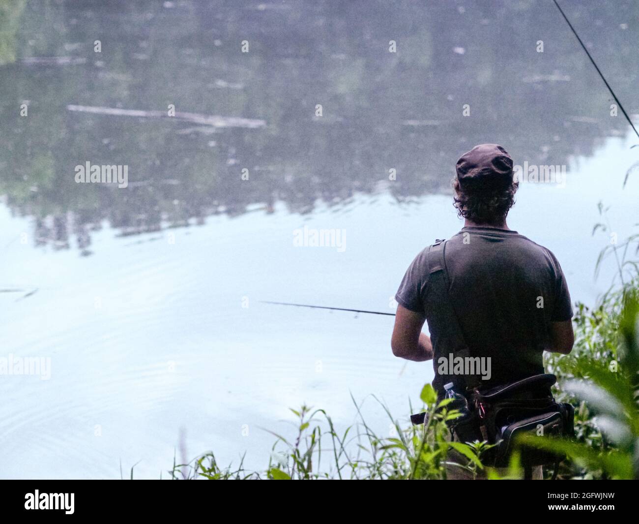 Rear view of man fishing by the river Stock Photo - Alamy