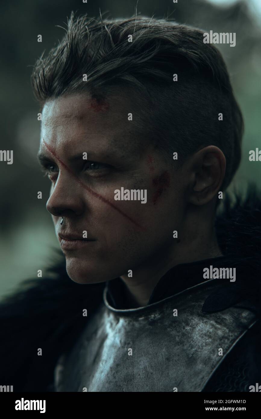 Portrait of medieval warrior knight in armour with bloody face and scar ...