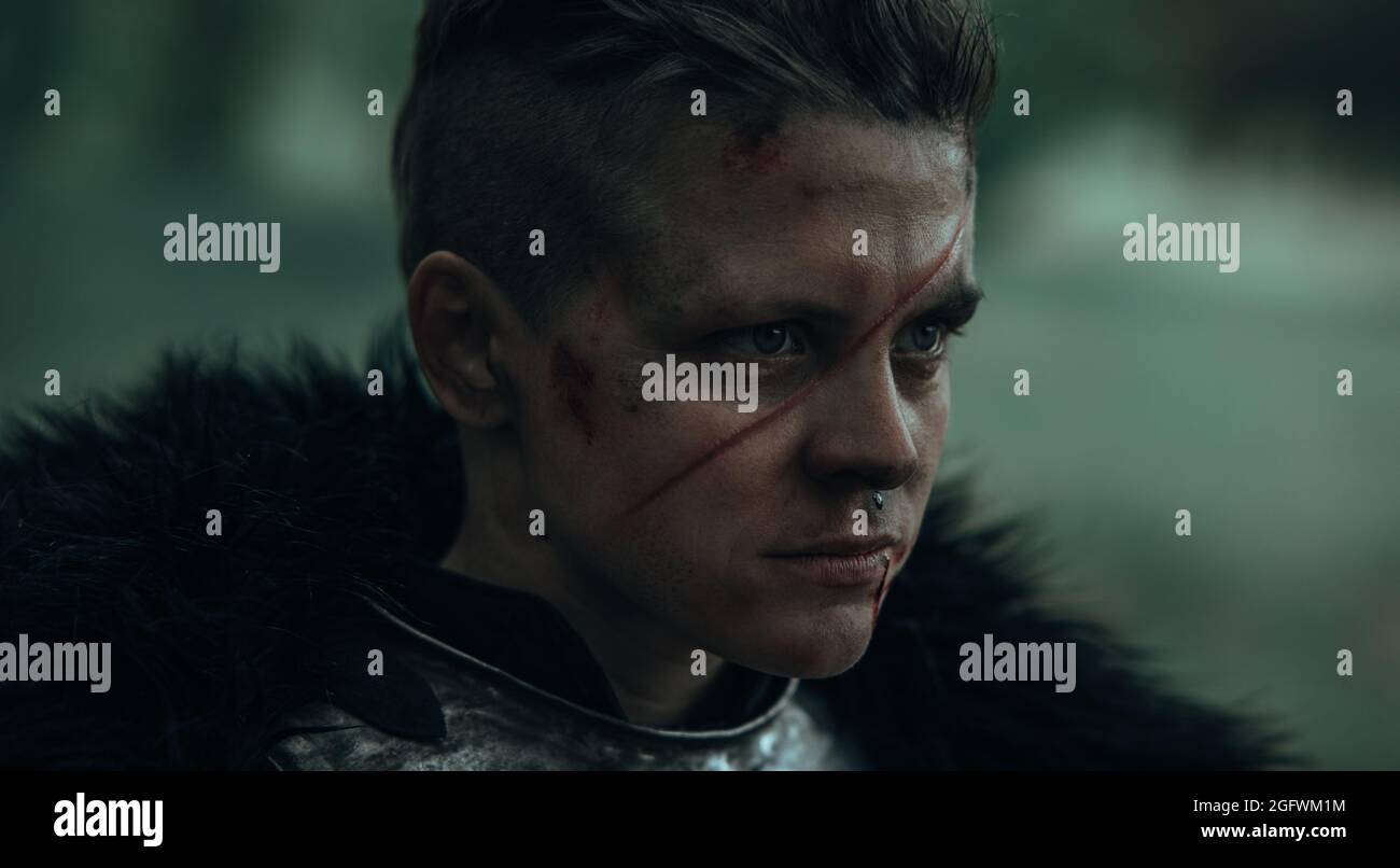 Portrait of medieval warrior knight in armour with bloody face and scar ...