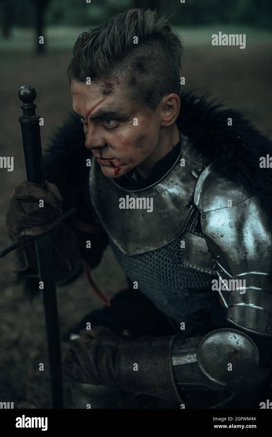 Portrait of medieval warrior knight with bloody face in chain mail ...