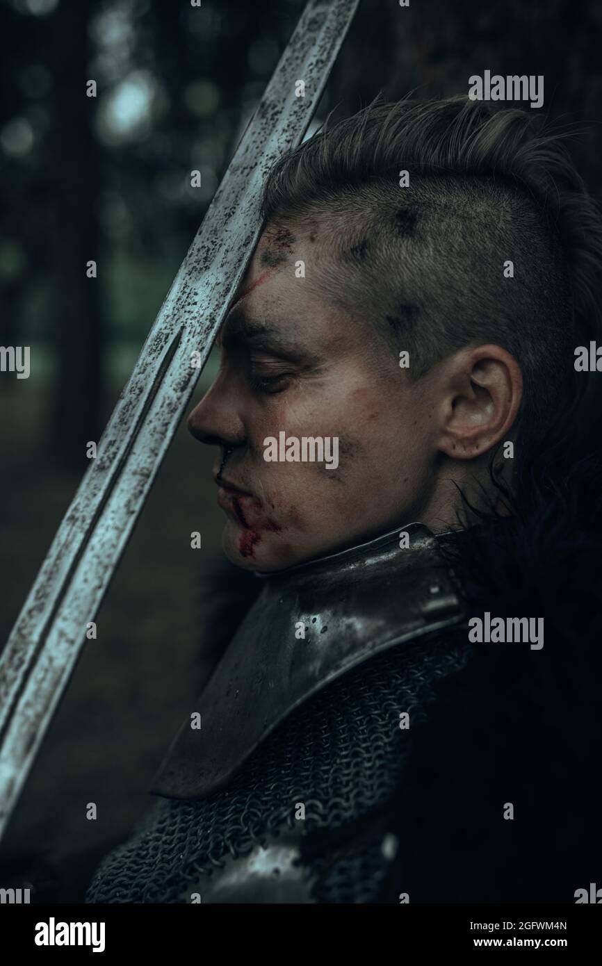 Portrait of medieval tired warrior knight with bloody face in chain ...