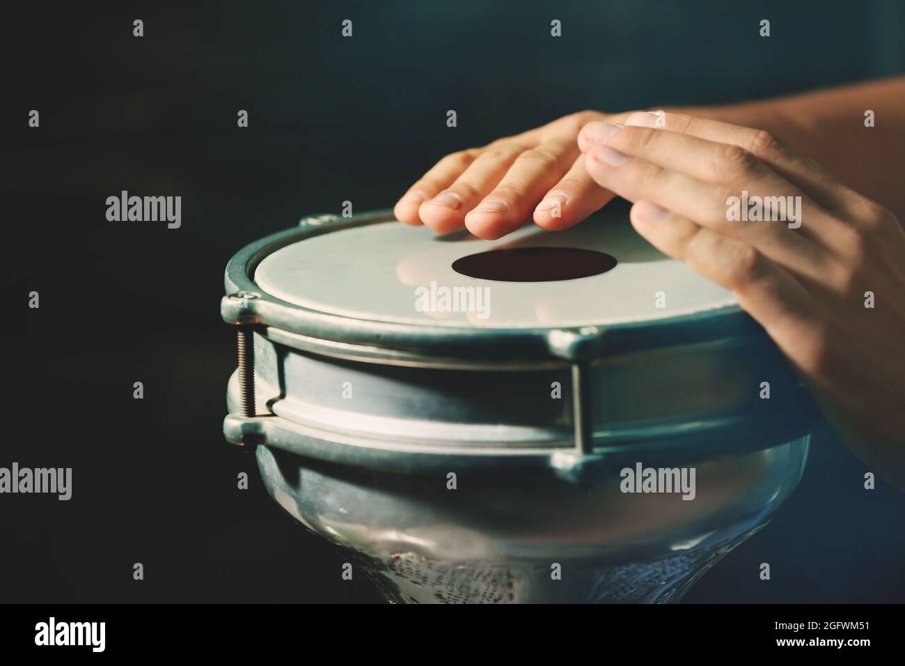 Hands of man playing African drum on dark background Stock Photo - Alamy