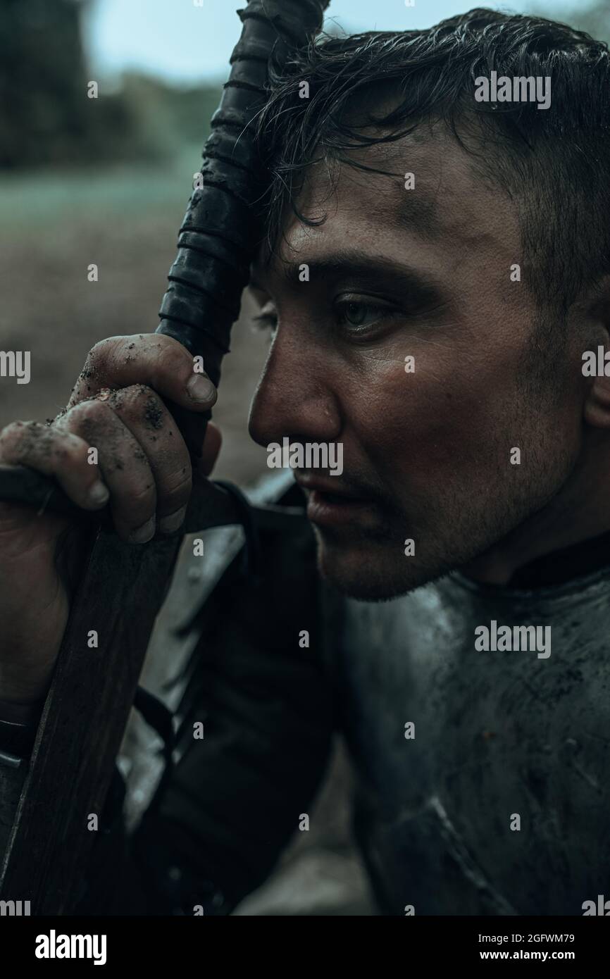 Portrait of medieval tired warrior knight with dirty face in armour ...