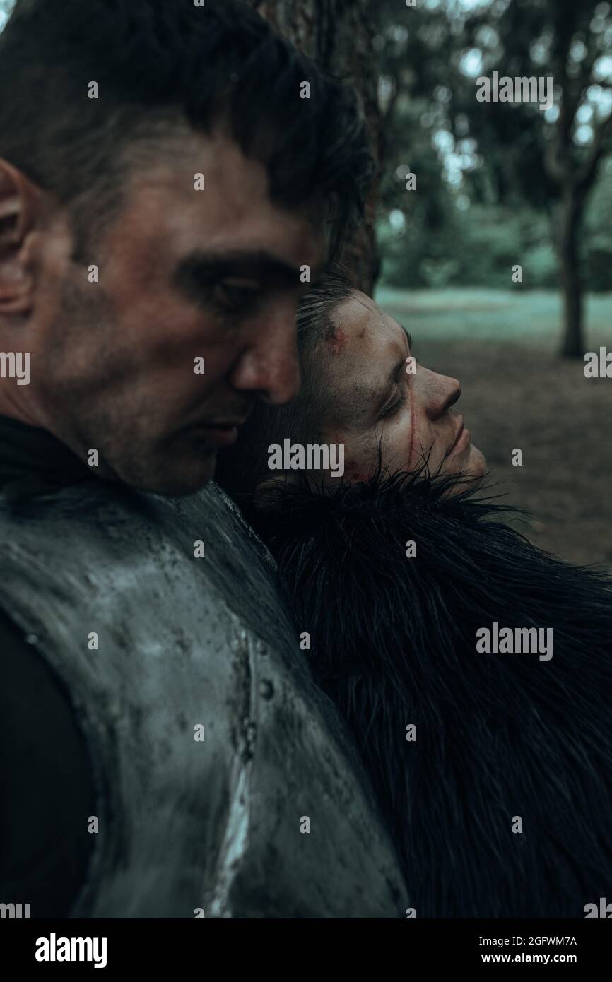 Two tired medieval warriors knights in chain mail armour sit and rest ...