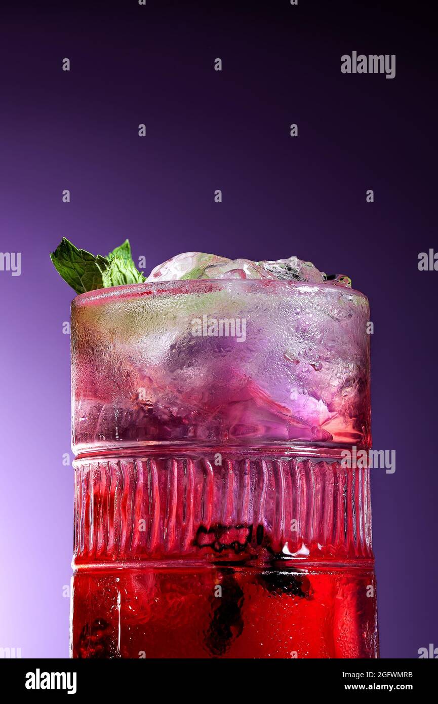 Iced berry sparkling cocktail with mint close-up. Vegan soft drink ...