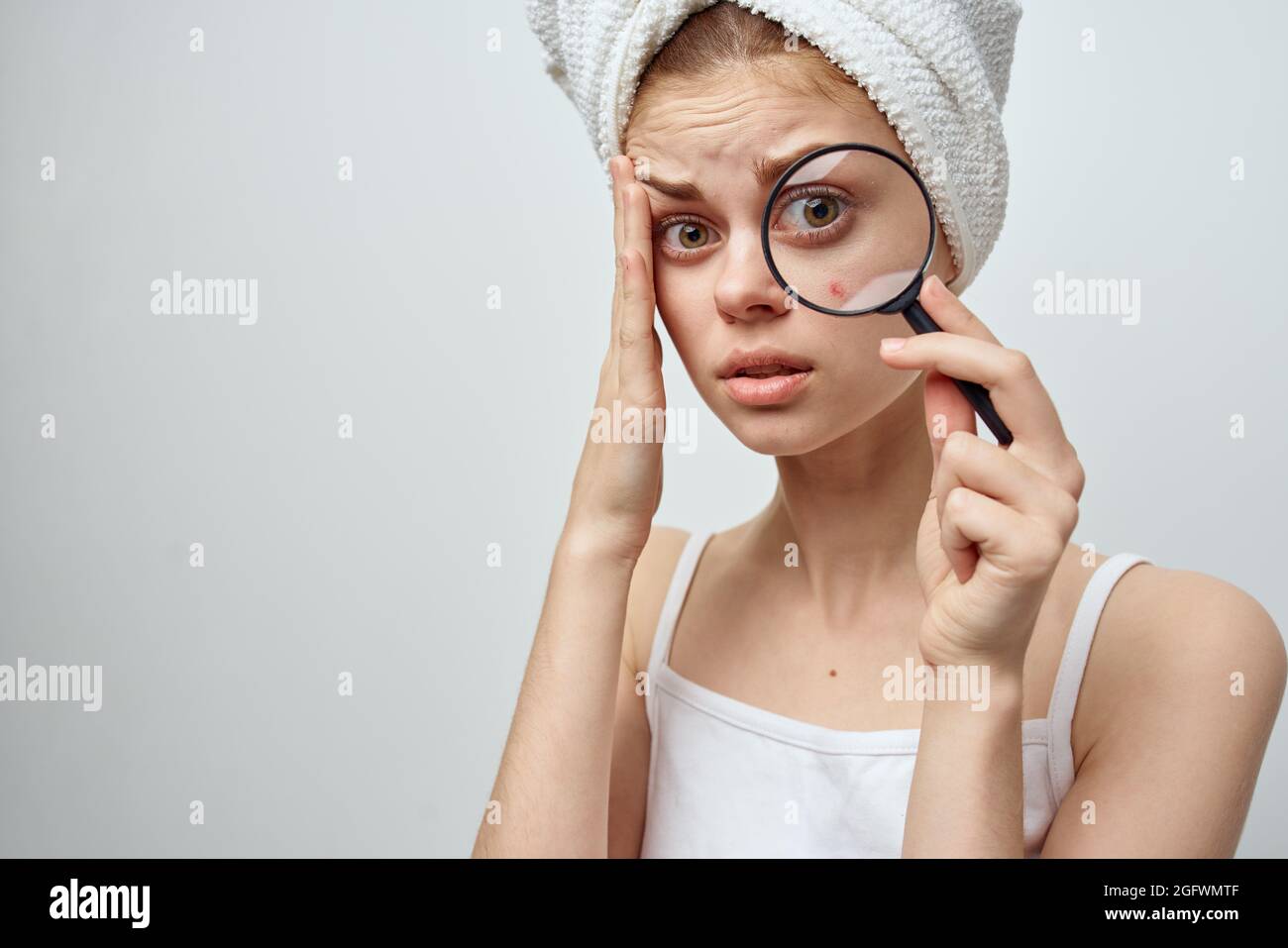 pretty woman with a magnifying glass in hand skin problems close-up ...