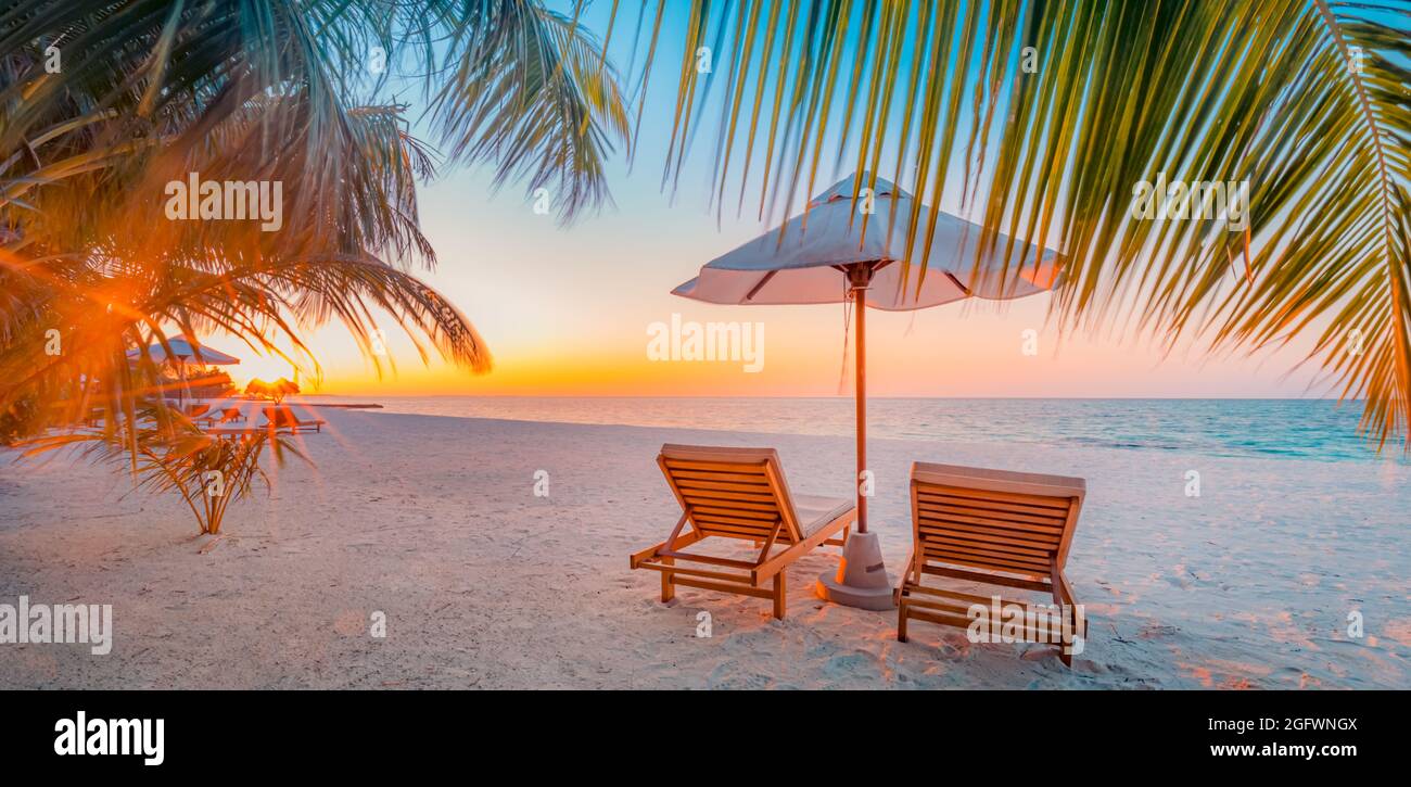 Amazing tropical sunset scenic, two sun beds, loungers, umbrella palm ...