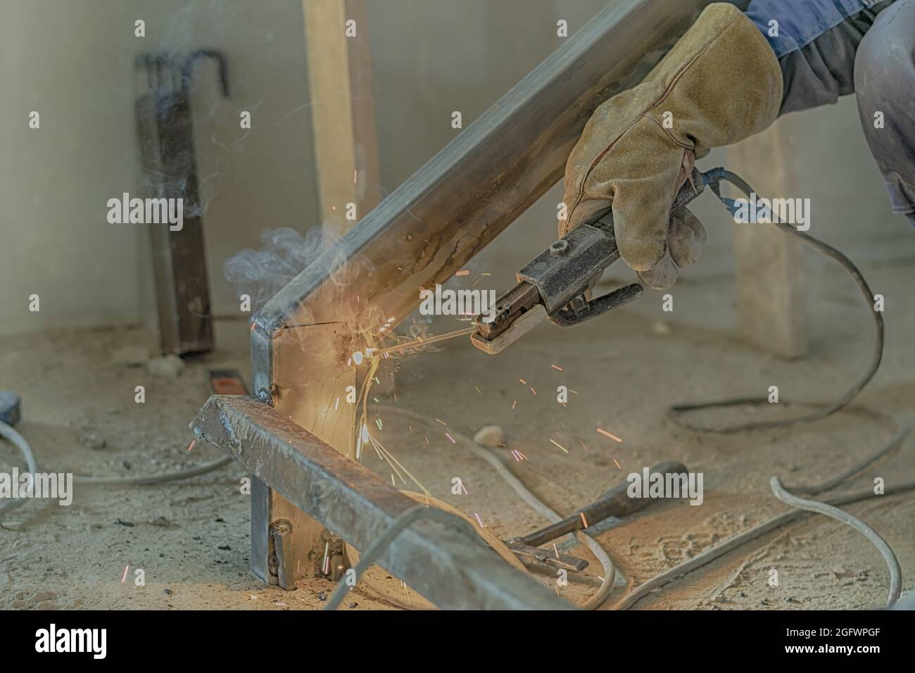 Cut-off male hands of worker hold welding machine with which he ...
