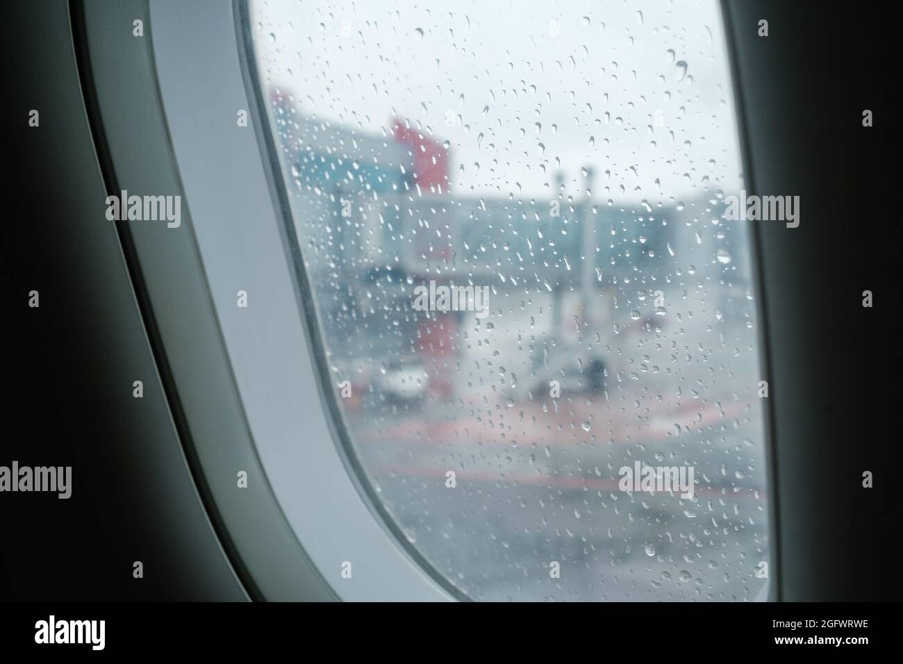 Airfield behind wet plane window Stock Photo - Alamy