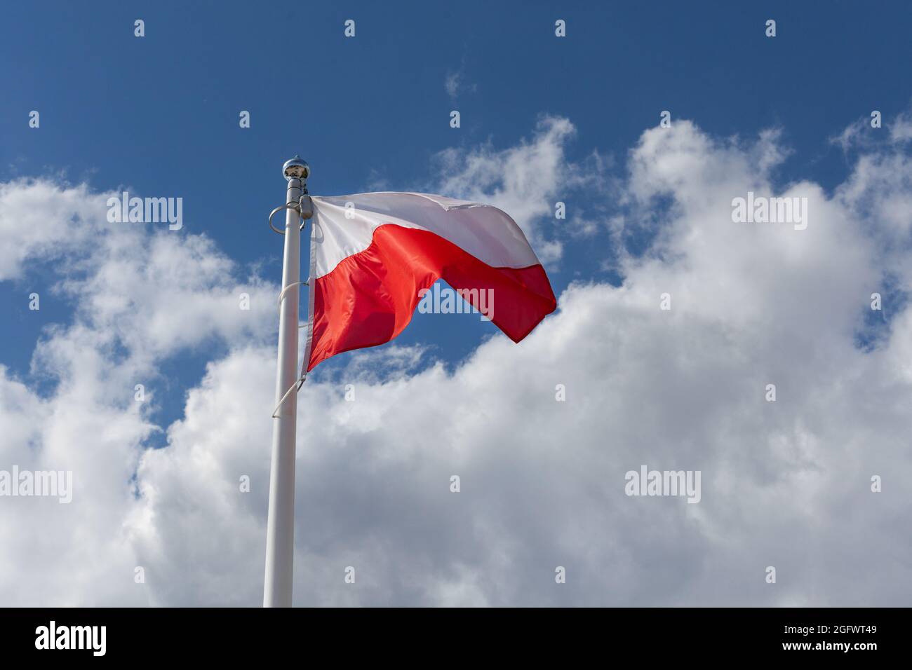 Polish national flag and blue spring sky. National symbol of Poland on ...