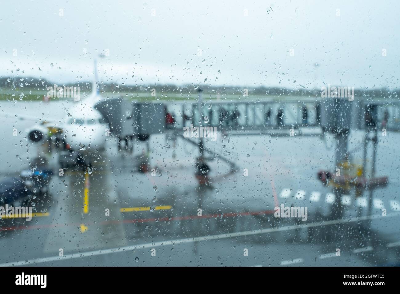 Jetway and plane behind wet glass Stock Photo - Alamy