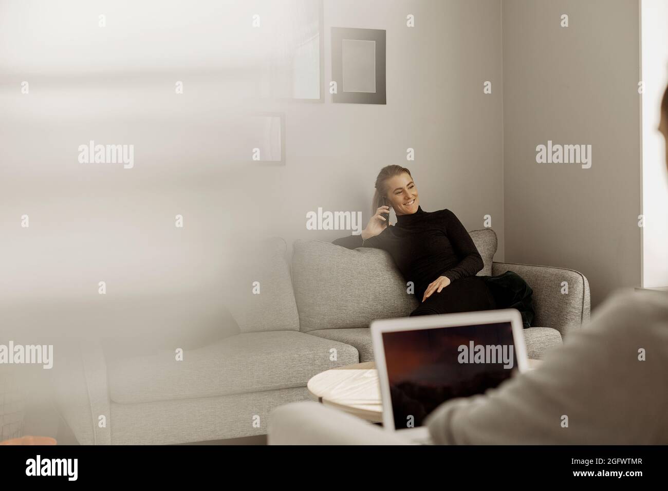 Woman on sofa using cell phone Stock Photo - Alamy