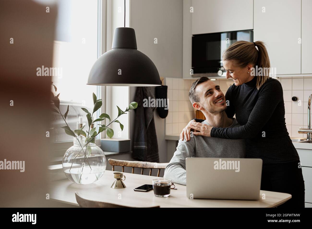 Couple hugging in kitchen Stock Photo - Alamy