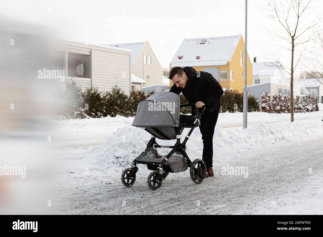 Man looking into pram during walk Stock Photo - Alamy