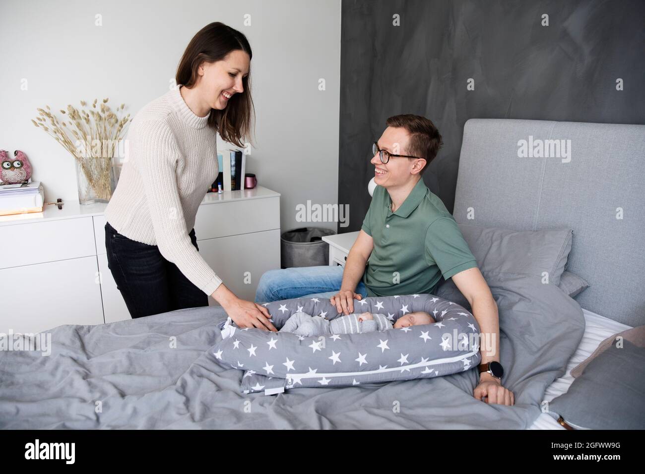 Parents putting baby son to sleep Stock Photo - Alamy