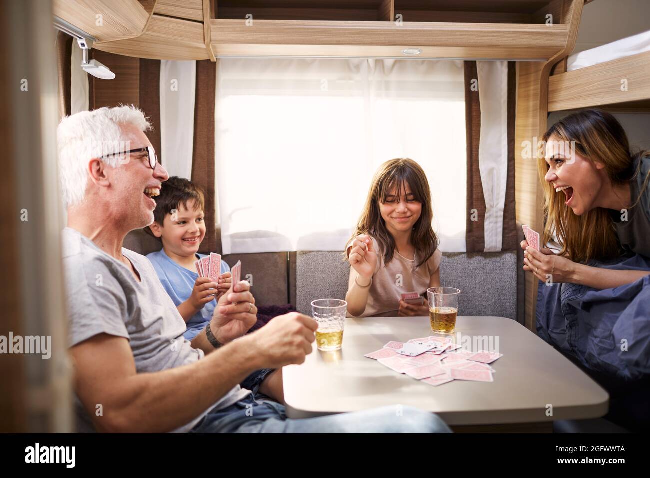 Family playing cards in camper van Stock Photo - Alamy