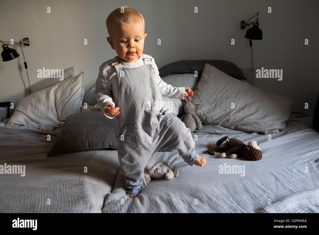 Baby boy walking on bed Stock Photo - Alamy