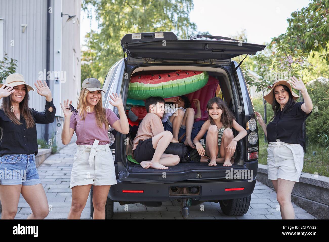 Family standing near car Stock Photo - Alamy