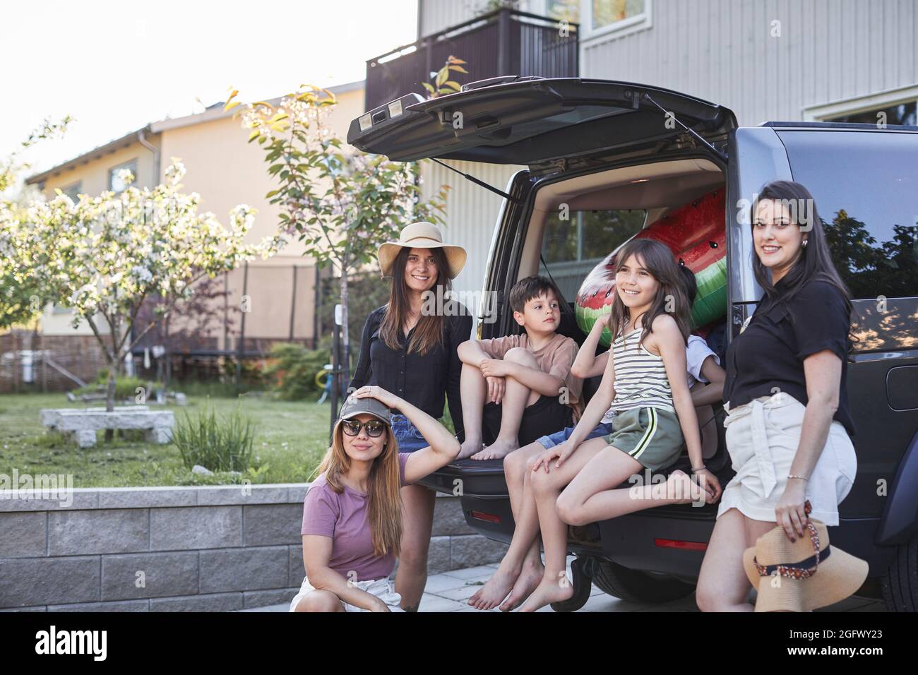 Family standing near car Stock Photo - Alamy