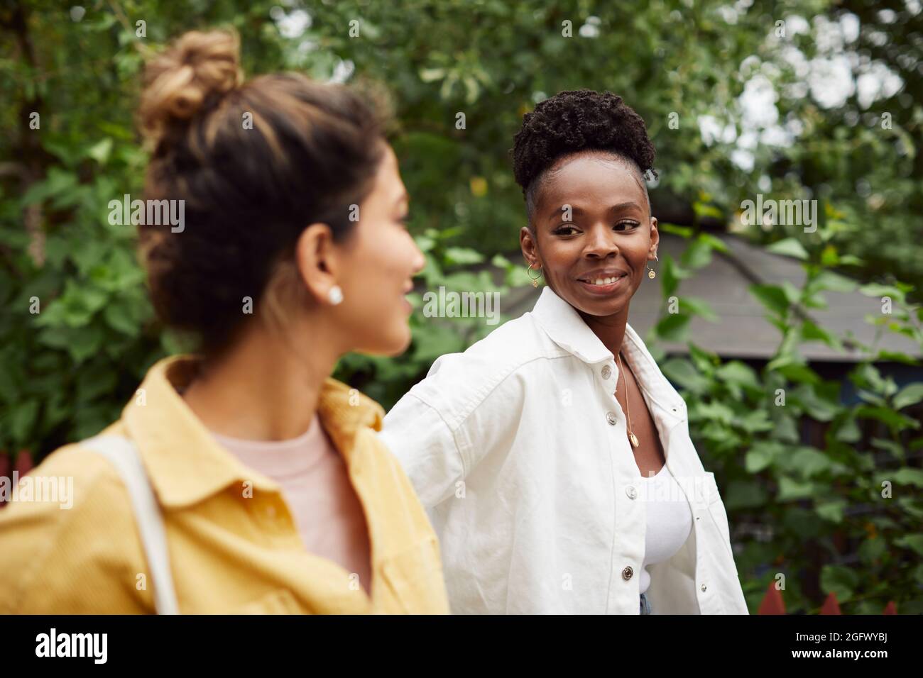 Smiling female friends talking Stock Photo - Alamy