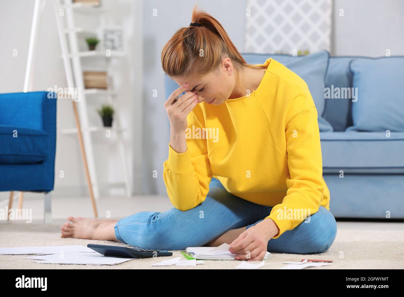 Confused young woman calculating taxes at home Stock Photo - Alamy