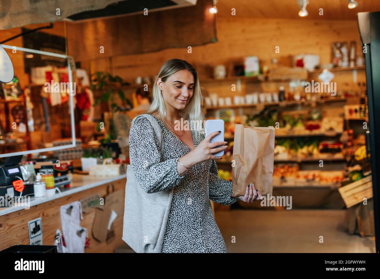 Smiling woman in shop taking picture Stock Photo - Alamy