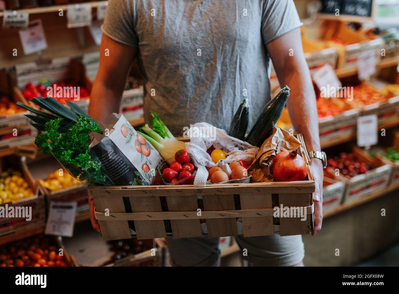 Man carrying crate with organic vegetable Stock Photo - Alamy