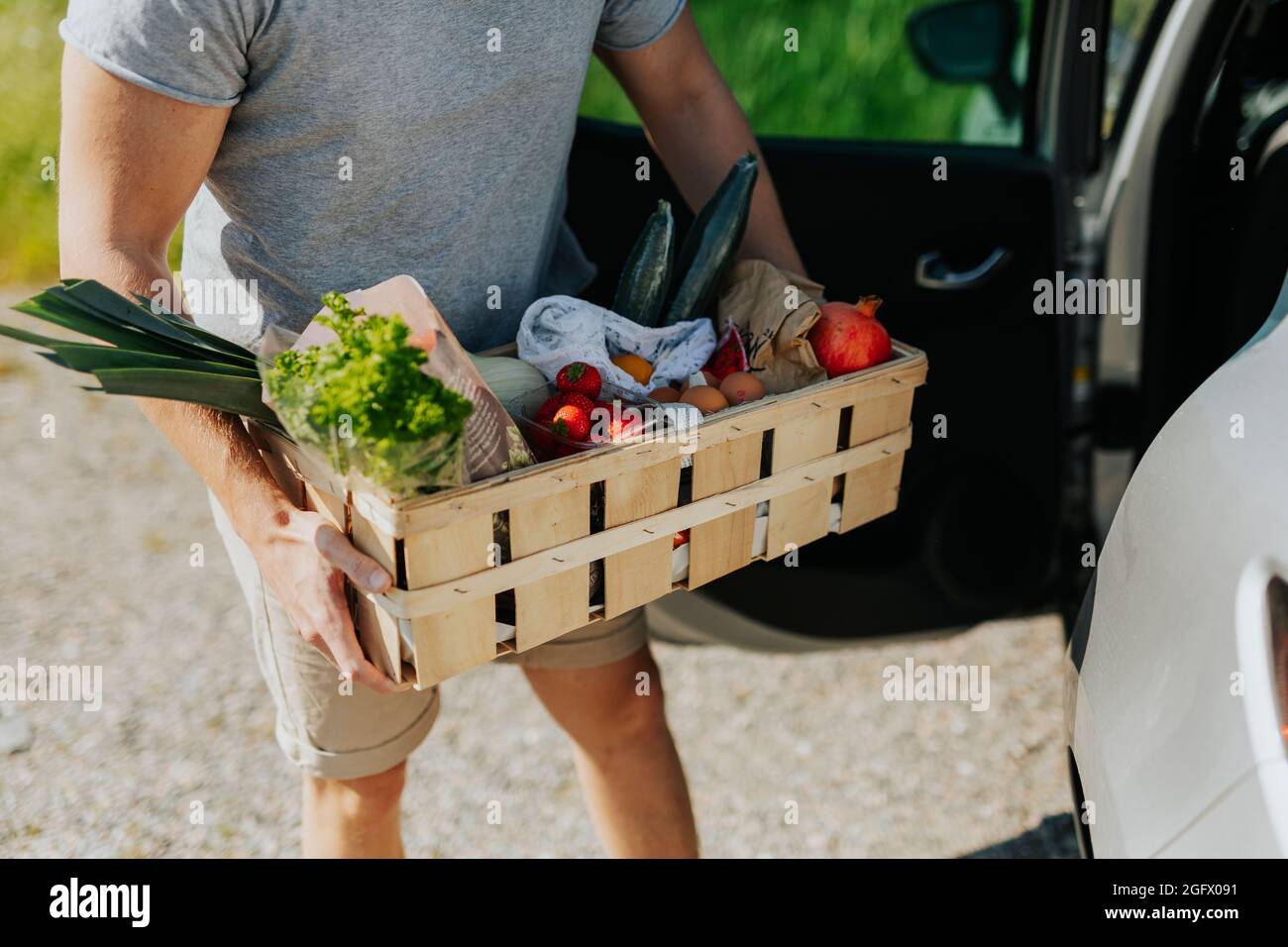 Man carrying crate with organic vegetable Stock Photo - Alamy