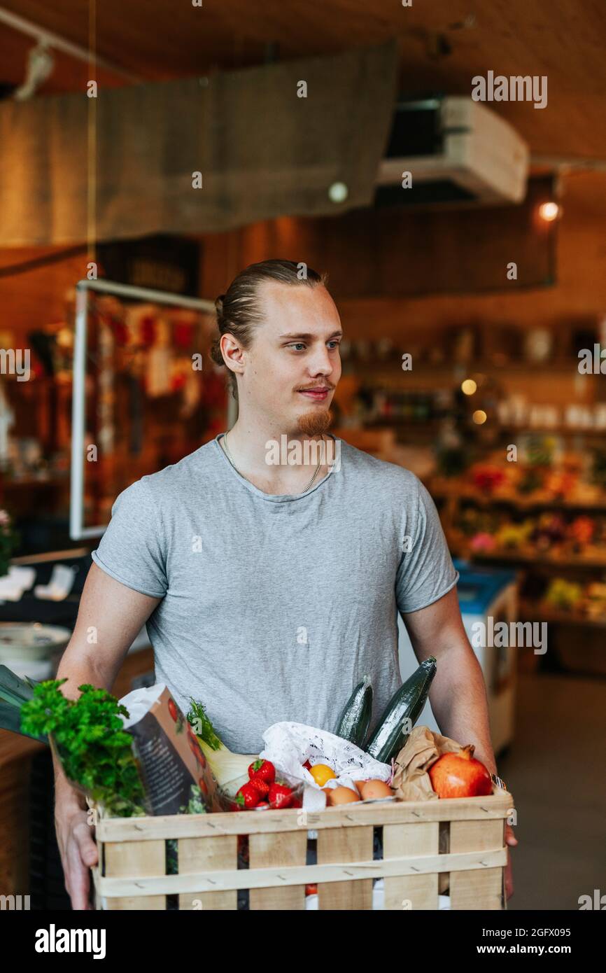Man carrying crate with organic vegetable Stock Photo - Alamy