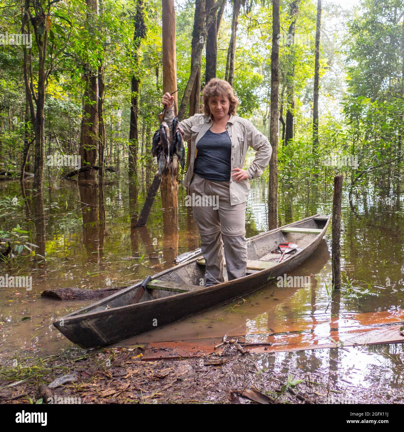 Caucasian woman in the small wooden boat with fishes catch from the ...