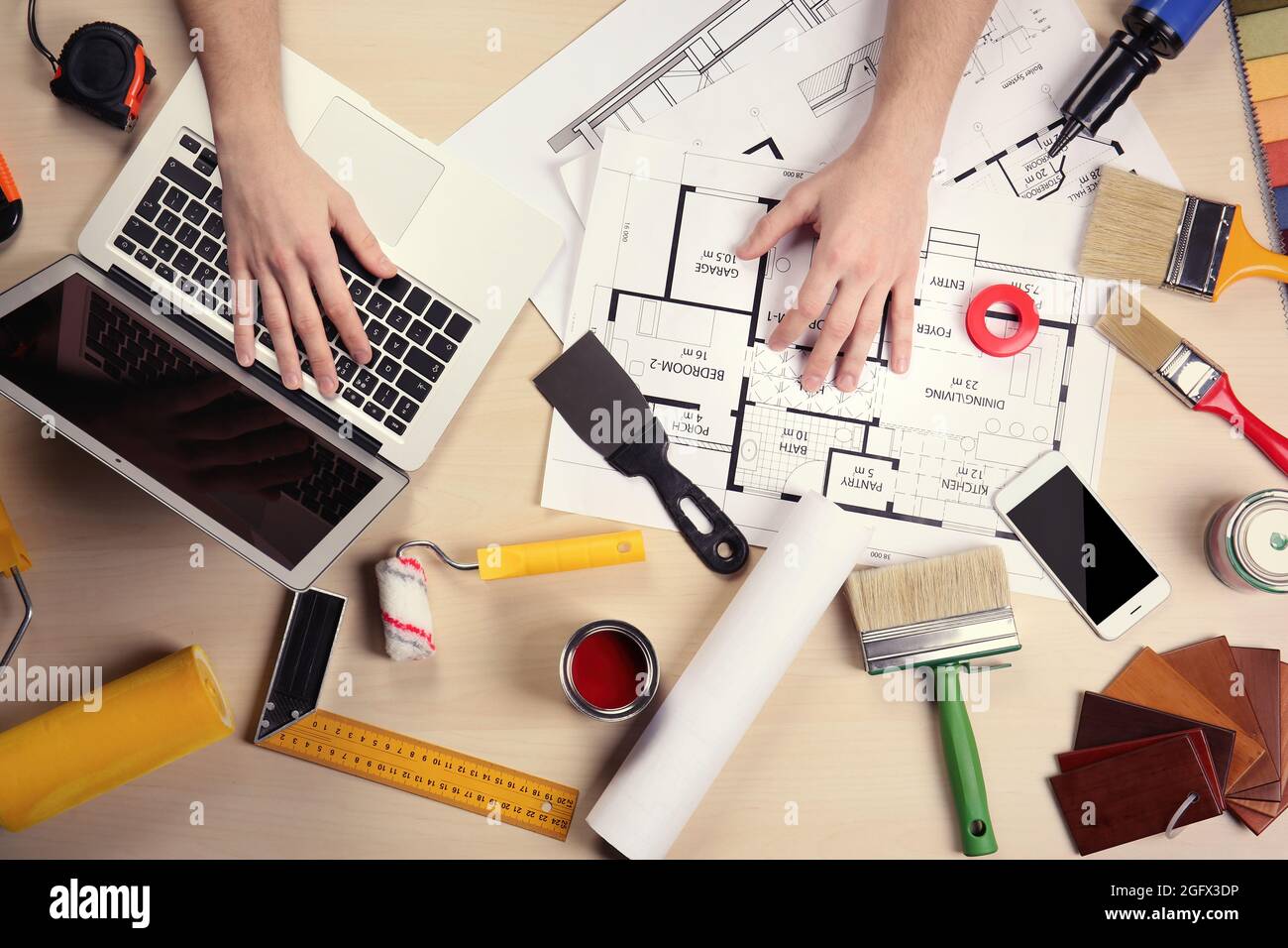 Decorator's hands working with laptop and project drawings. Color ...