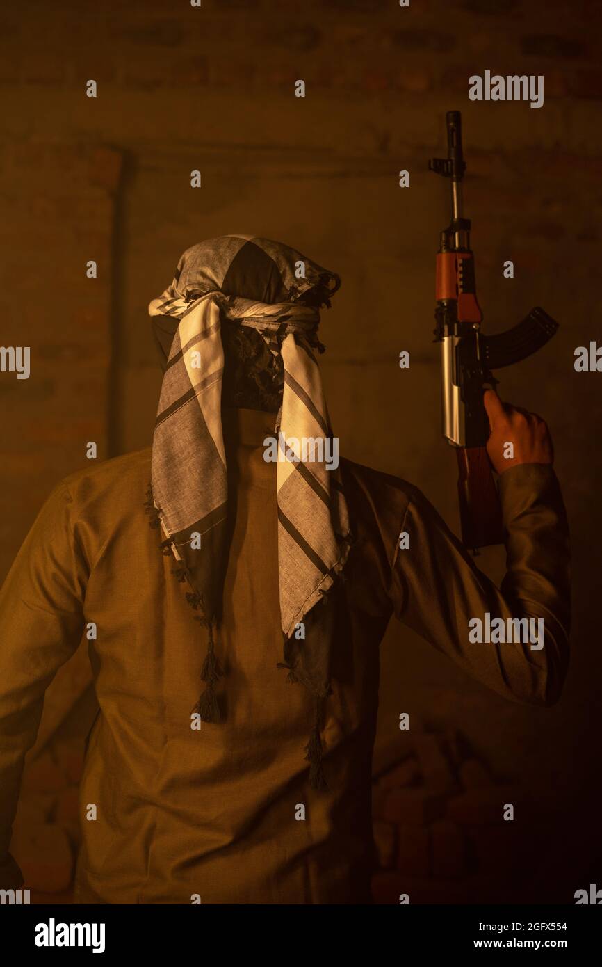 back view of unrecognizable militant with gun in hand - concept of ...