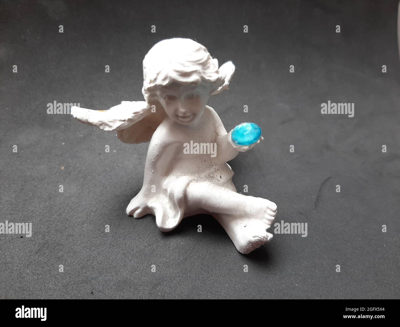 Deko Figur weiß Engel Kind sitzend mit einer blauen Kugel in der Hand ...