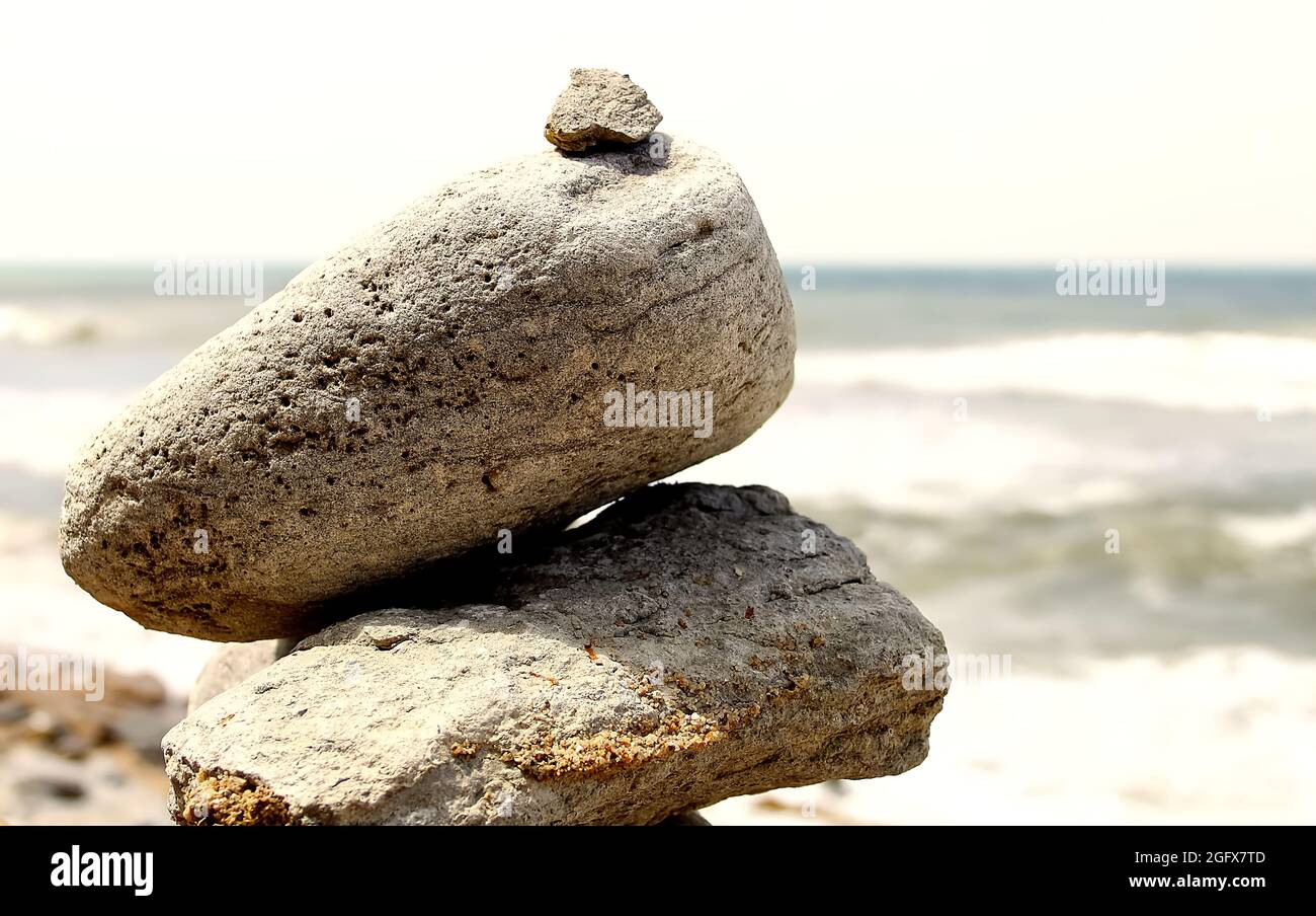 Closeup shot of a stone stacking in the beach with sea and skyb ...