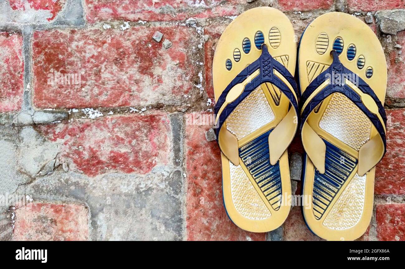 Old slippers on the red brick floor in india Stock Photo - Alamy