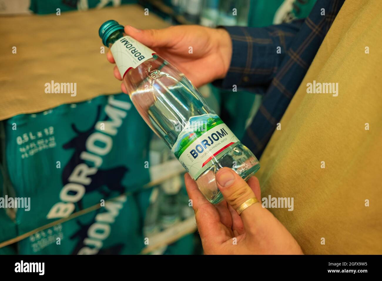 Odessa, Ukraine - August 2021. Man chooses mineral water in a store ...