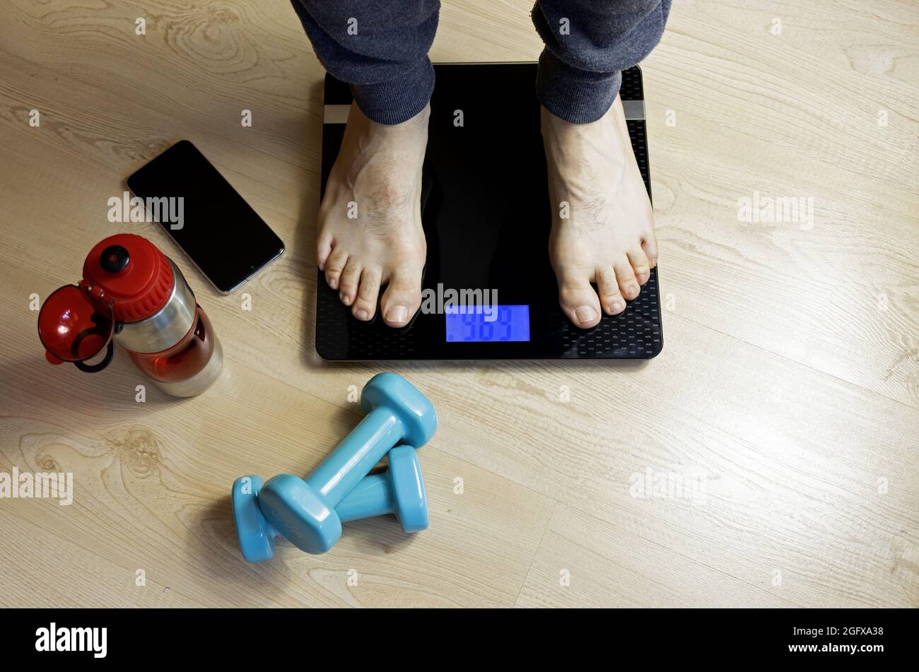 concept of good health and good weight, a person weighs himself on a ...