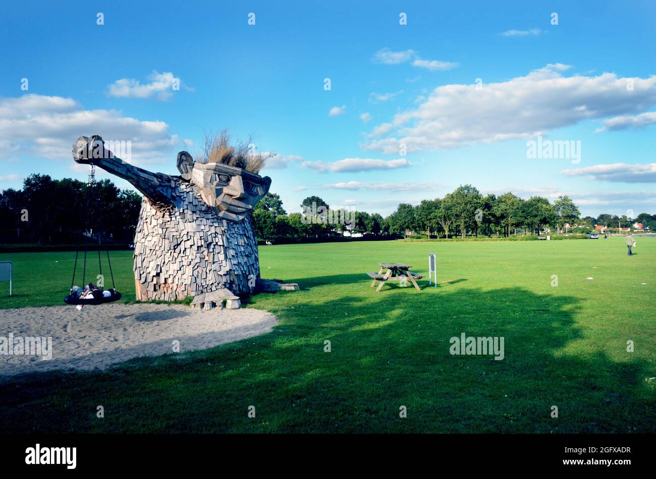 Beautiful park with green nature, a playground, and a rocky statue of a ...