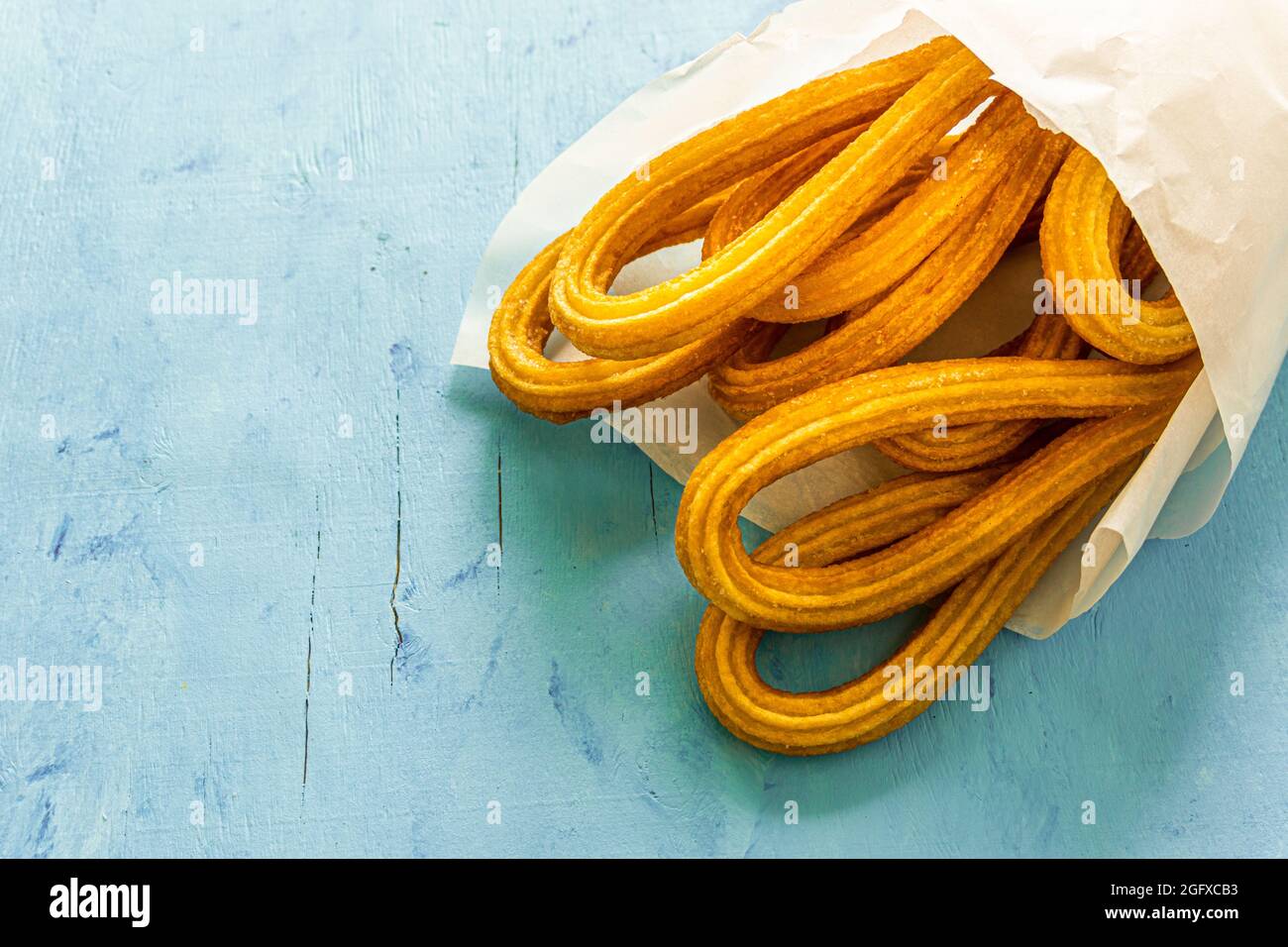 Close-up shot of deep-fried Spanish churros isolated on the blue ...