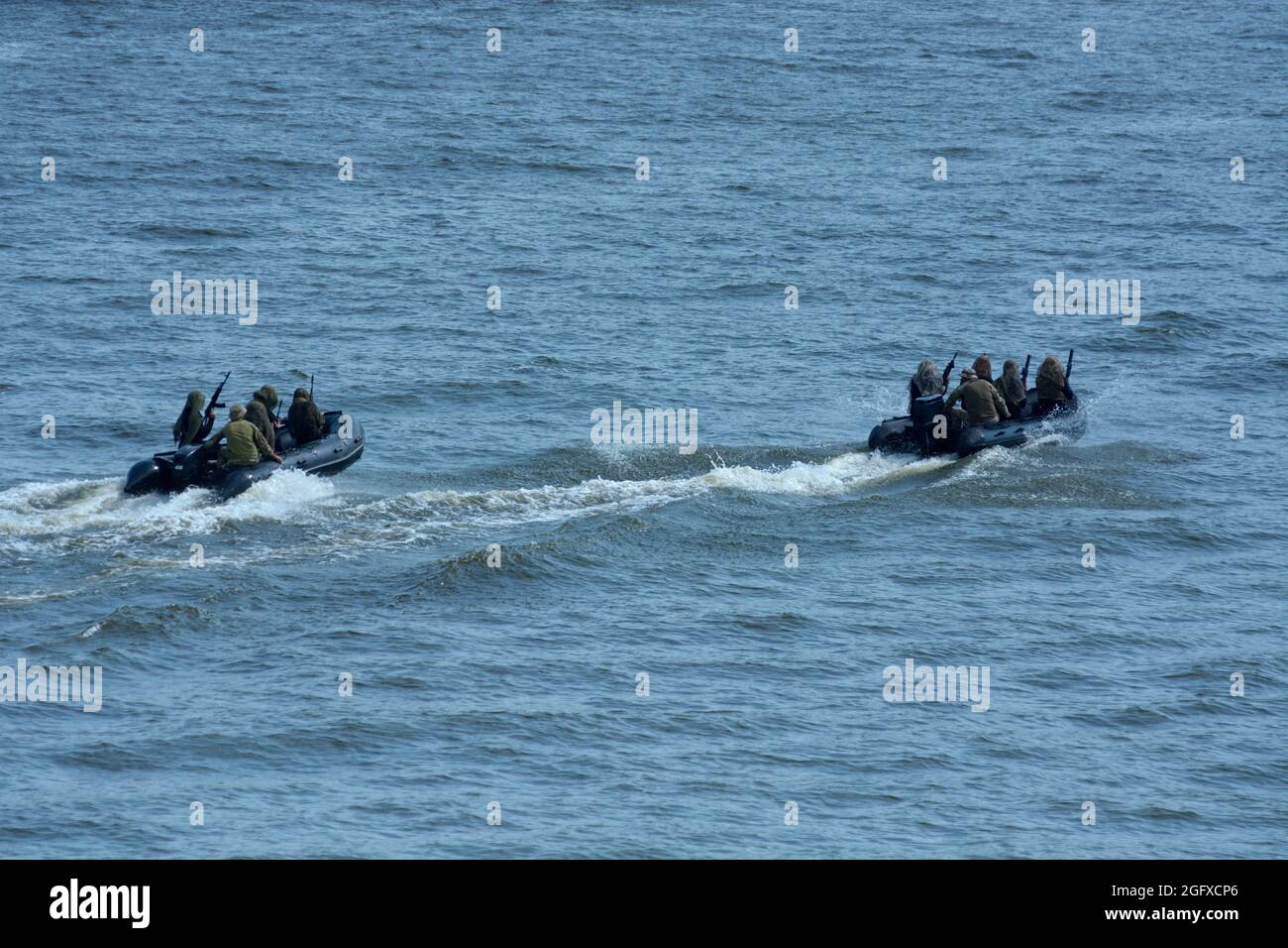 Miltary boats floating on water, armed soldiers of Special Forces ...