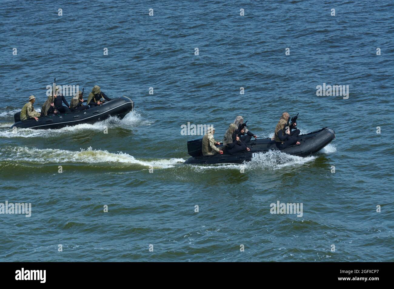Miltary boats floating on water, armed soldiers of Special Forces ...