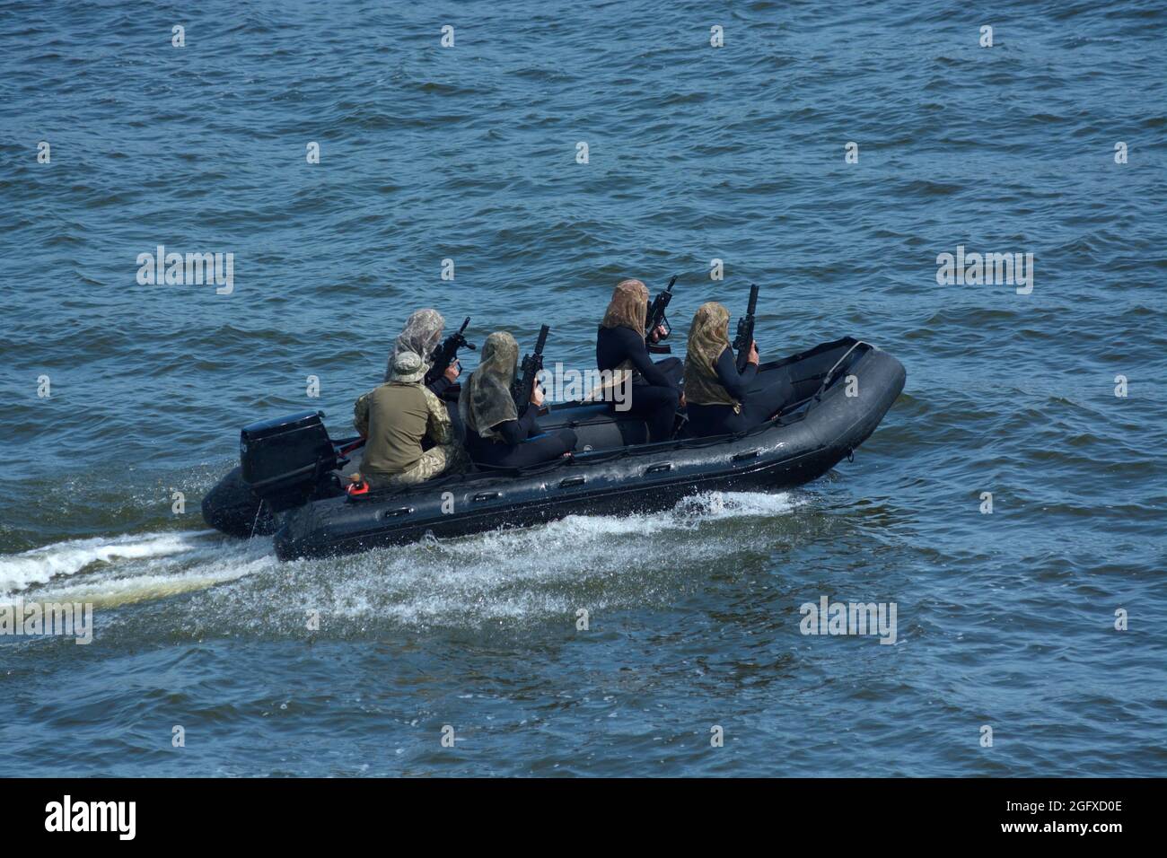 Miltary boat floating on water, armed soldiers of Special Forces aboard ...
