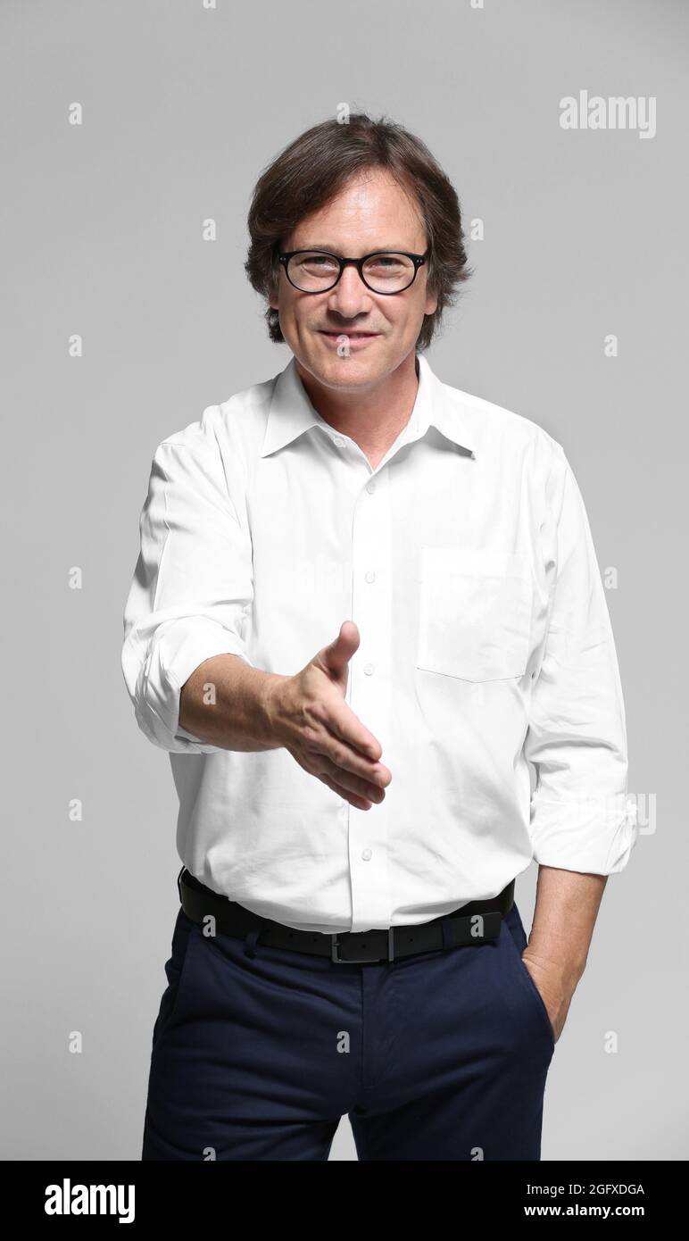 Mature man stretching out hand for shaking, on grey background Stock ...