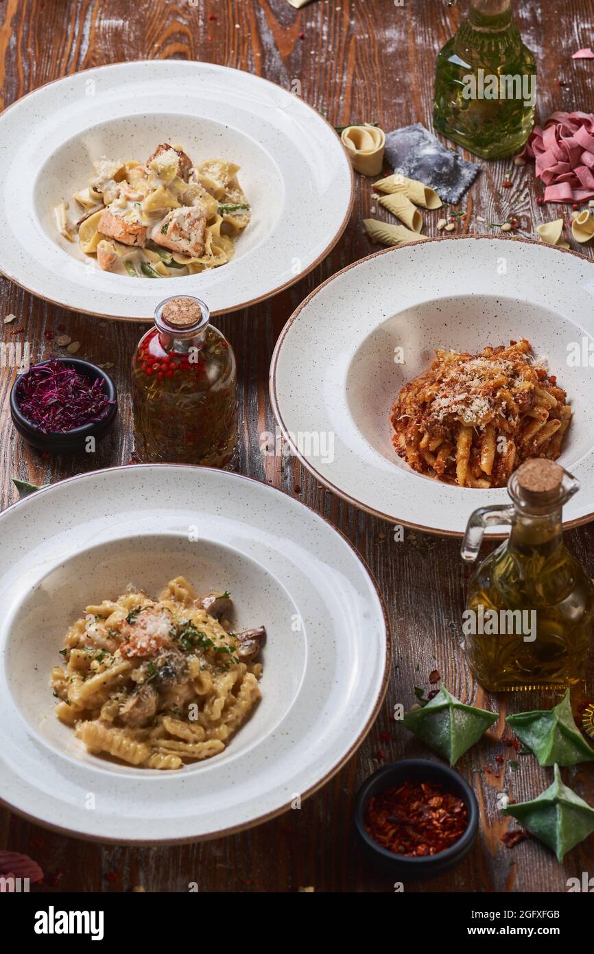 three types of Italian pasta on a wooden table Stock Photo - Alamy